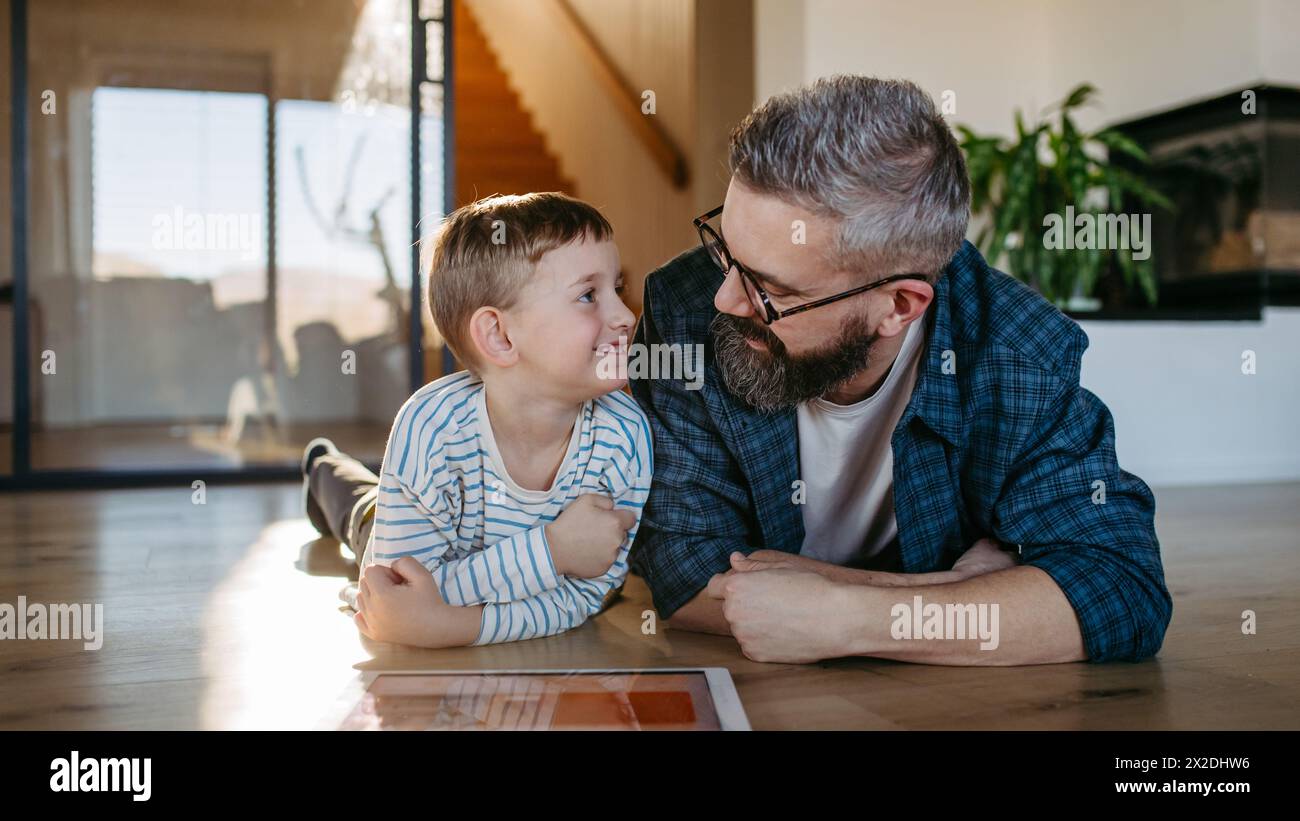 Father showing son smart home system, adjusting household functions ...