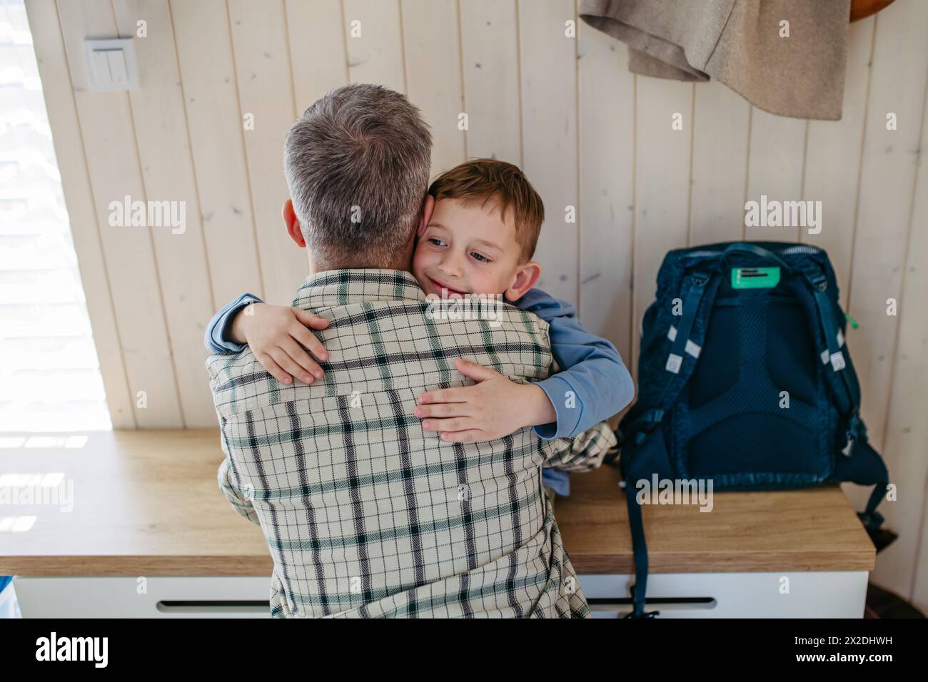 Father helping son get ready for kindergarten, preschool. Hugging ...