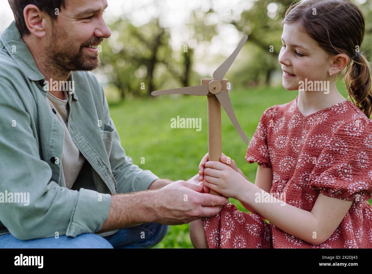 Father teaching daughter about renewable wind energy, sustainable ...
