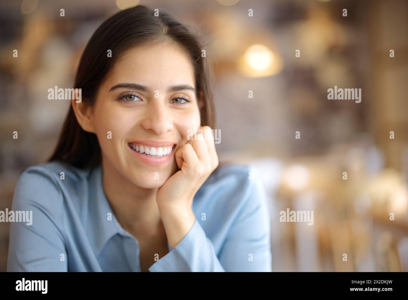 Portrait of a happy woman with perfect smile posing looking at you in a ...