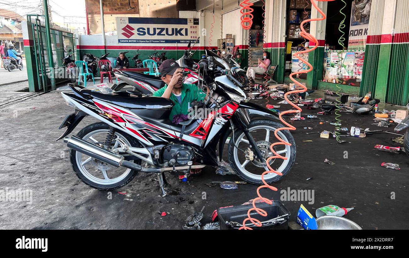 mechanic in overalls making diagnostics of motorbike near toolbox in ...