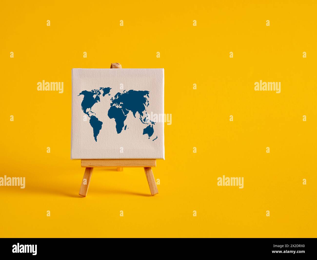 A canvas with world map symbol on an easel with yellow background with ...