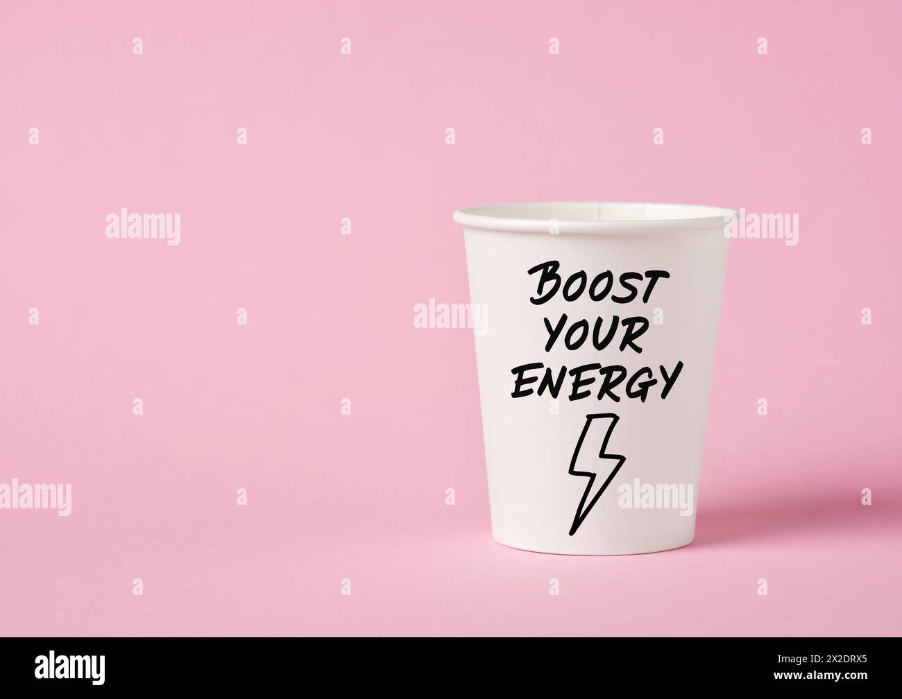 Boost your energy message on a paper coffee cup on pink background ...