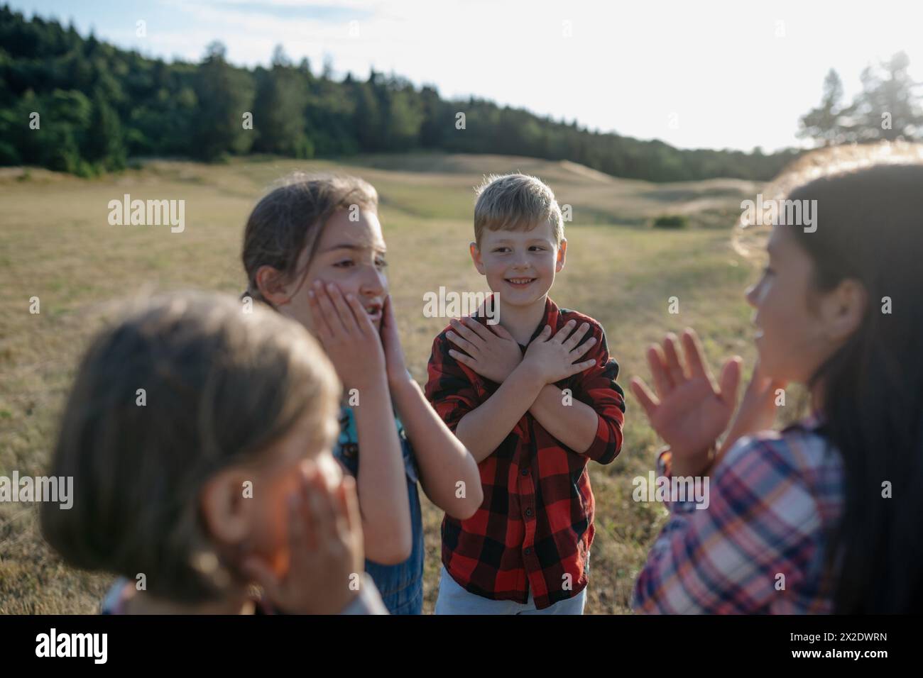 Portrait of young classmate playing hand clapping game outdoors ...