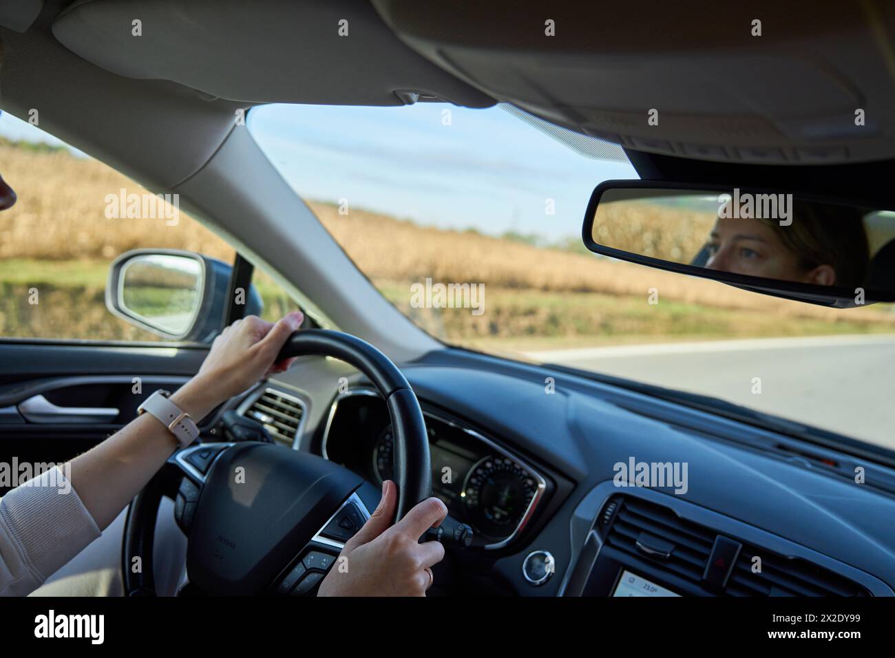 Inside view of woman driving car on countryside road. Female drivers ...
