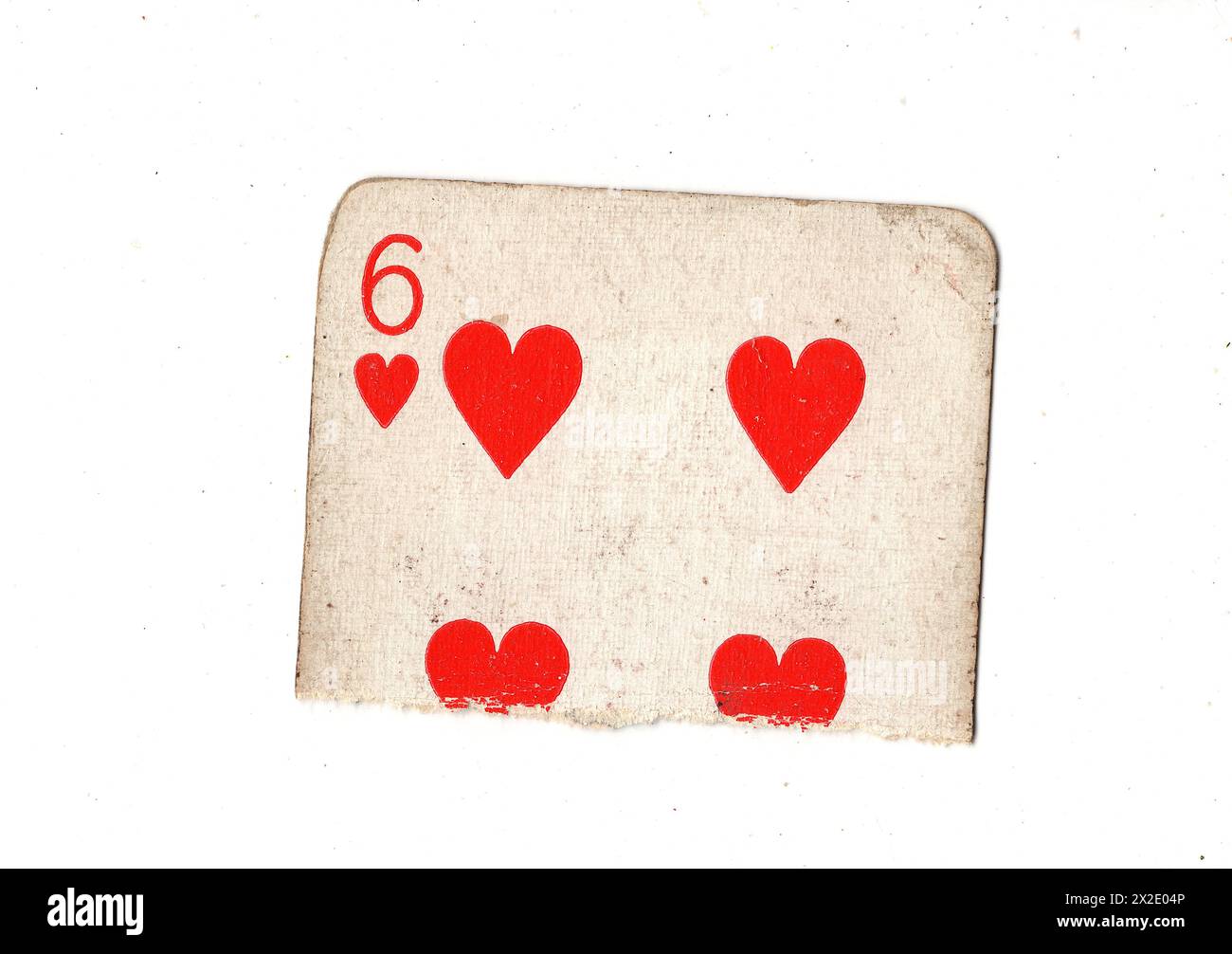 A torn half of a vintage, well used six of hearts isolated on a white ...