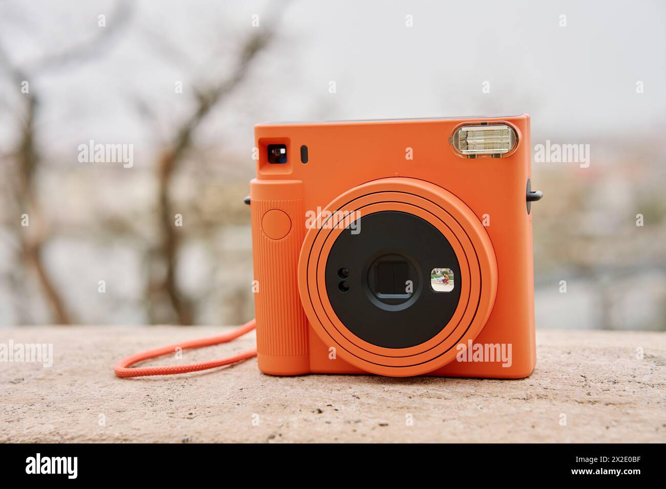 Vintage Orange Instant Camera in city with cloudy sky. Travel shooting ...
