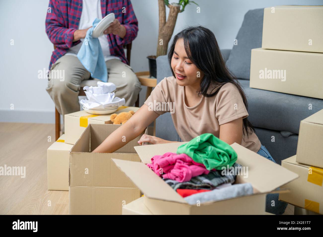 The couple is moving household items into their new home Stock Photo ...