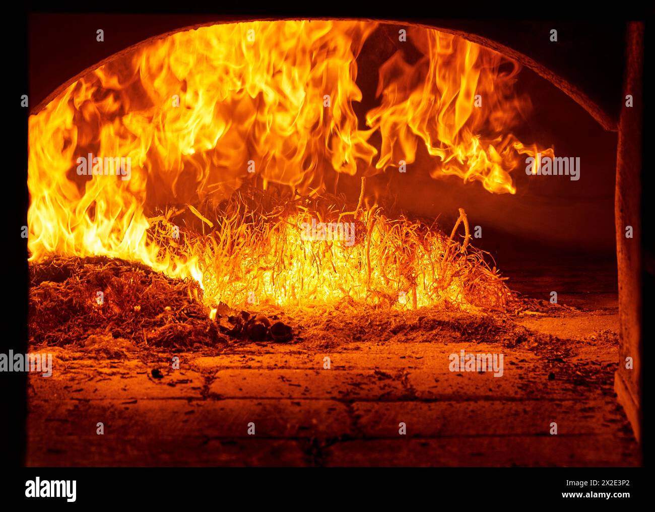 Closeup of fire in a furnace where twigs and logs are burning. Detail ...