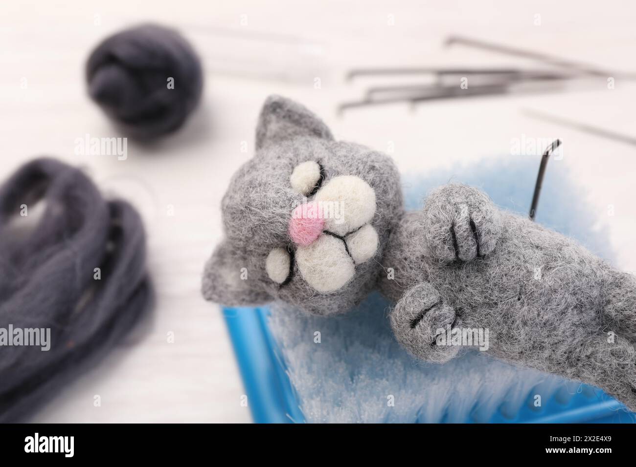Felted cat, wool, needles and brush on light table, closeup Stock Photo ...
