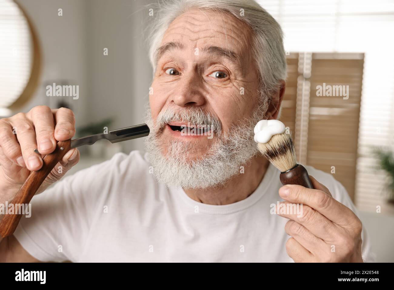 Man shaving mustache and beard with blade in bathroom Stock Photo - Alamy
