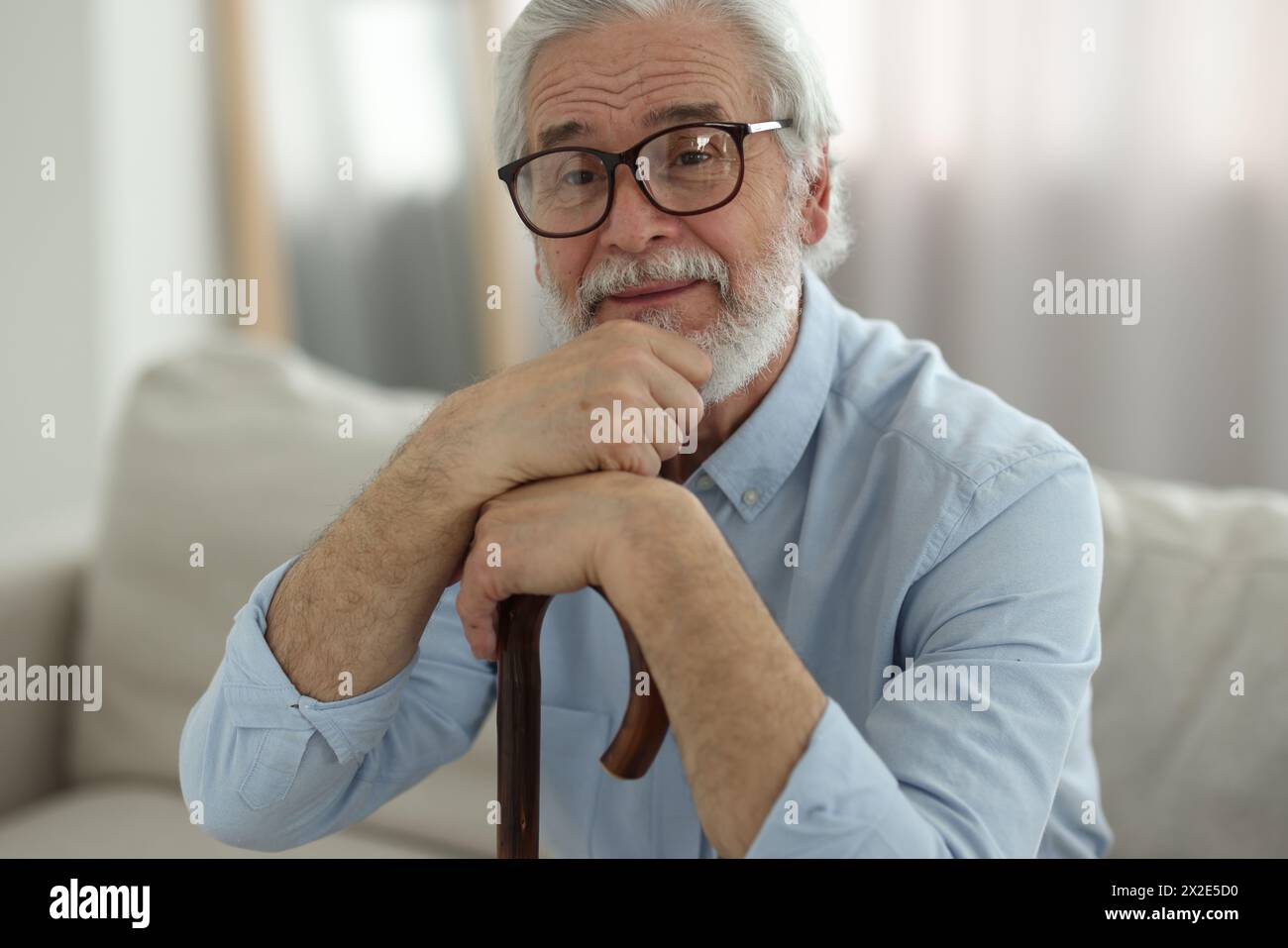 Portrait of grandpa with glasses and walking cane on sofa indoors Stock ...