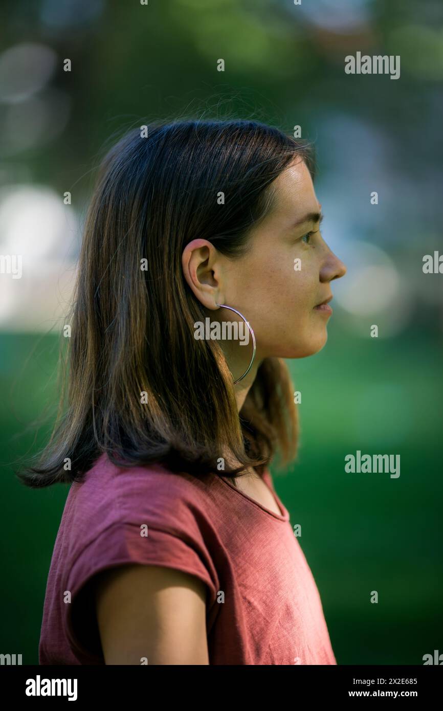 Captured in profile, the woman maintains a serene expression, exuding ...