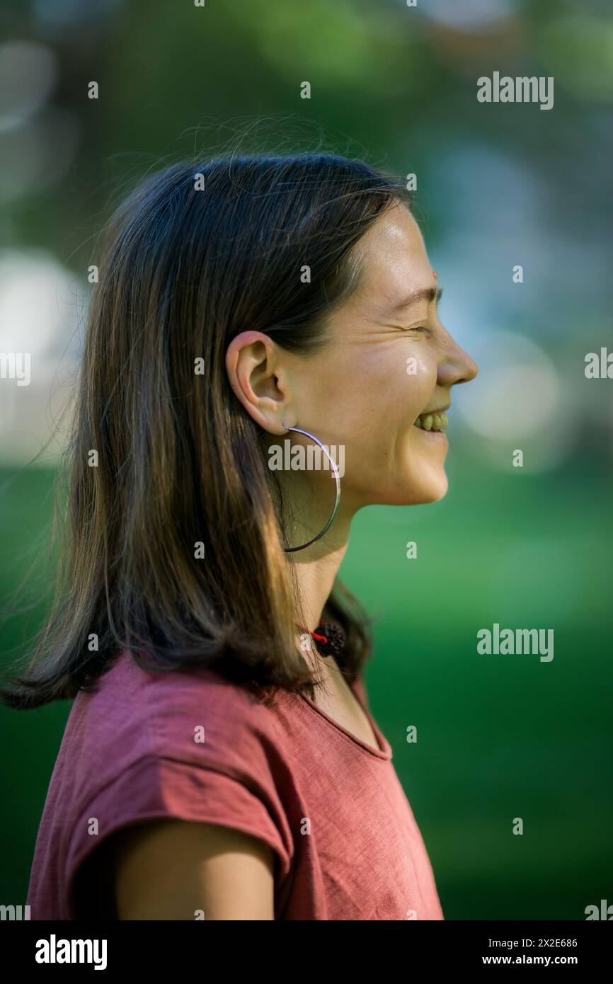Profile with a smile: A woman beams brightly in profile, her smile ...