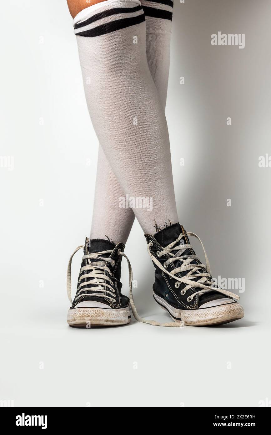 Old blue sneakers hipster style on girl legs in over the knee socks, on ...