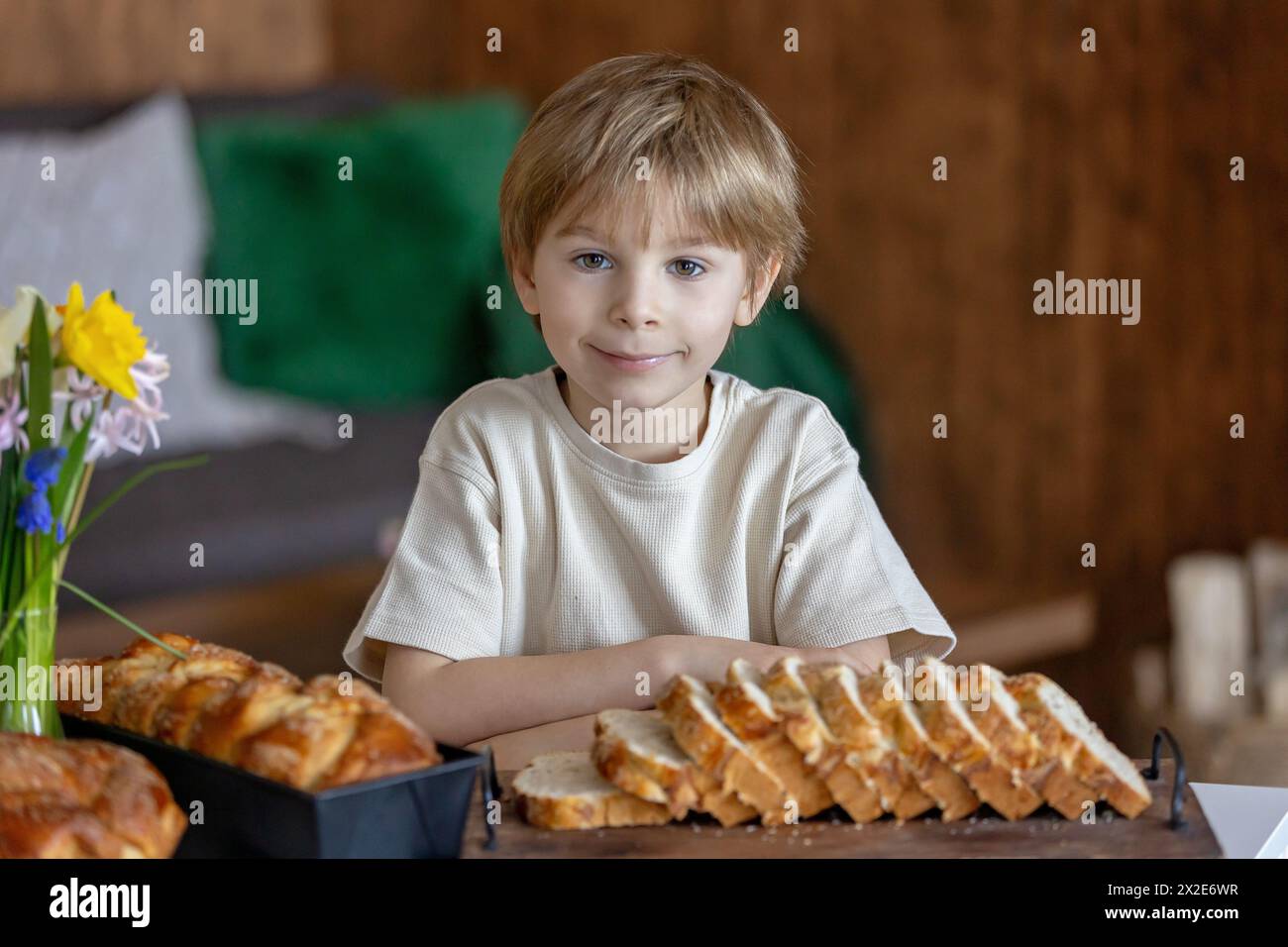 Cute preschool child, boy, holding sweet brioche bun for Easter ...