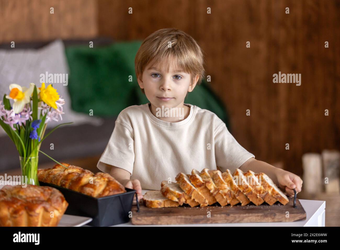 Cute preschool child, boy, holding sweet brioche bun for Easter ...