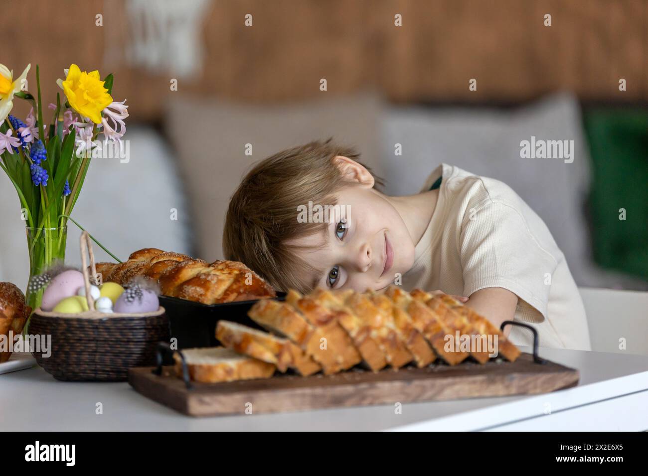 Cute preschool child, boy, holding sweet brioche bun for Easter ...