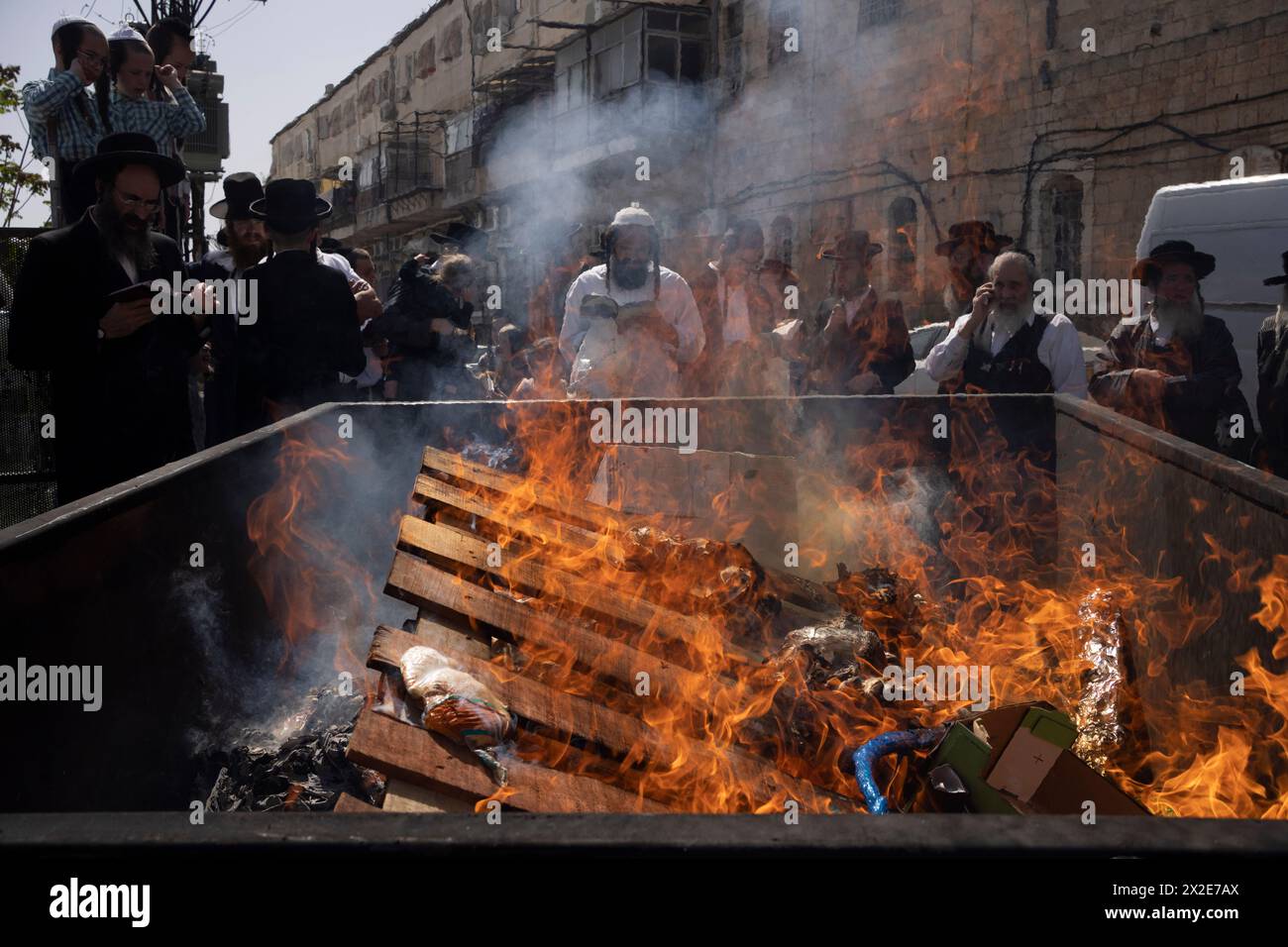 Ultra-Orthodox Jewish men pray next to a container as they burn ...