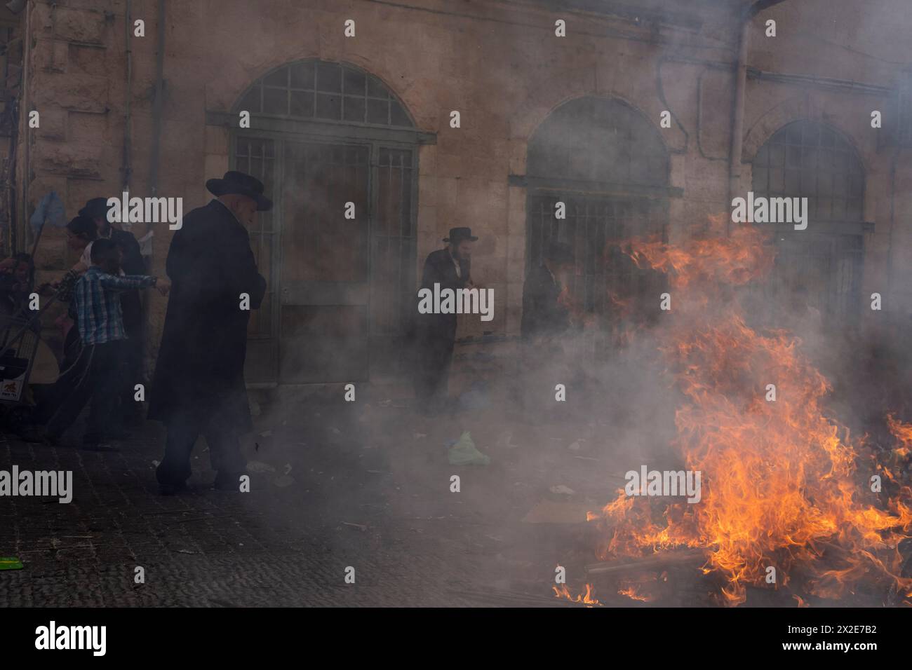 Ultra-Orthodox Jewish men stand next to the fire as they burn leavened ...
