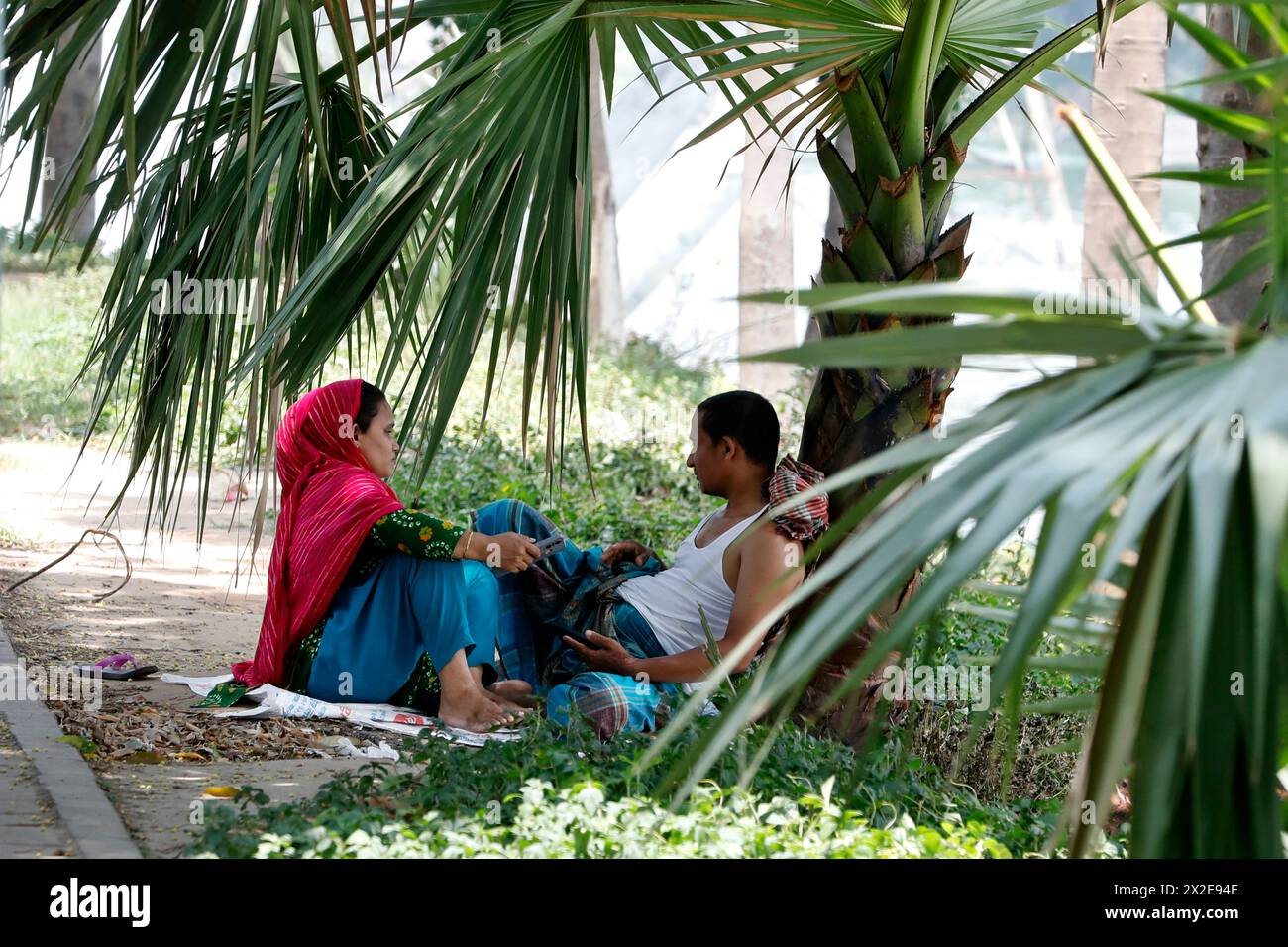 Dhaka, Bangladesh - April 22, 2024: Due to the intense heat, many people are sitting in the ...