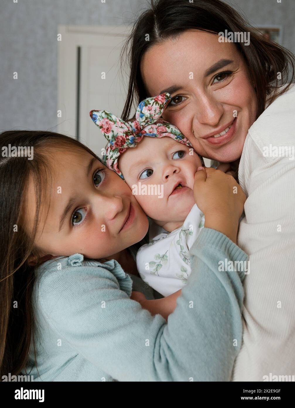 A happy loving family Mother and her little girl daughters hug Stock ...
