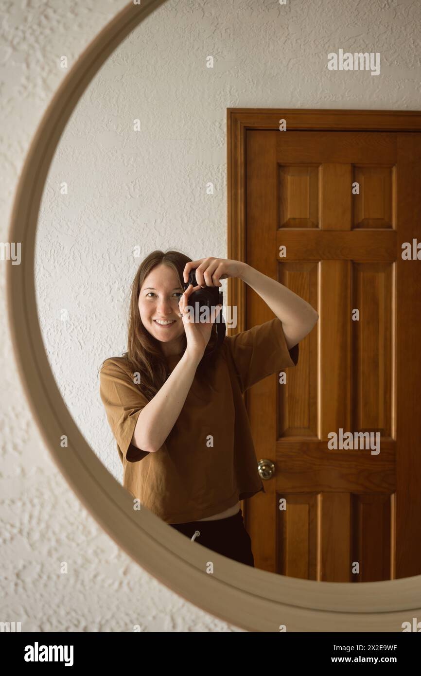 Woman smiles at reflection in mirror while taking a candid photo Stock ...
