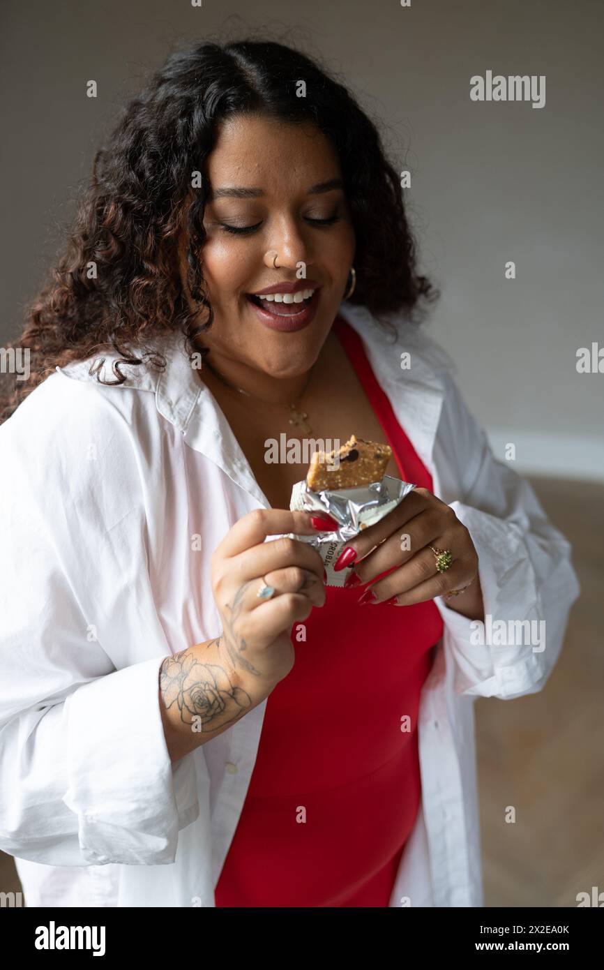 woman eating a vegan protein bar Stock Photo - Alamy