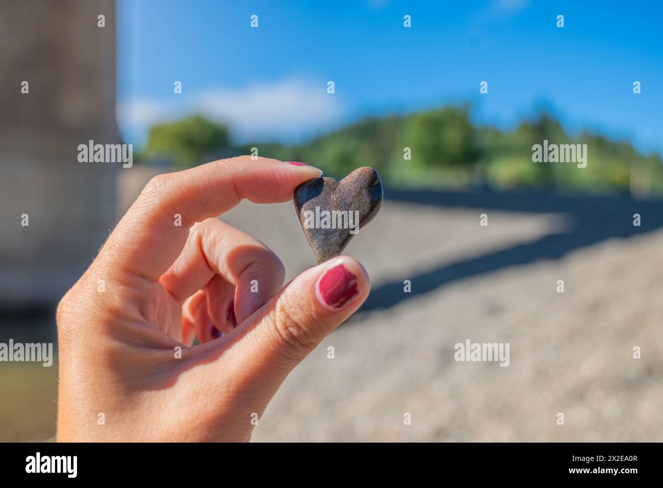Woman holding heart shaped rock in hand Stock Photo - Alamy