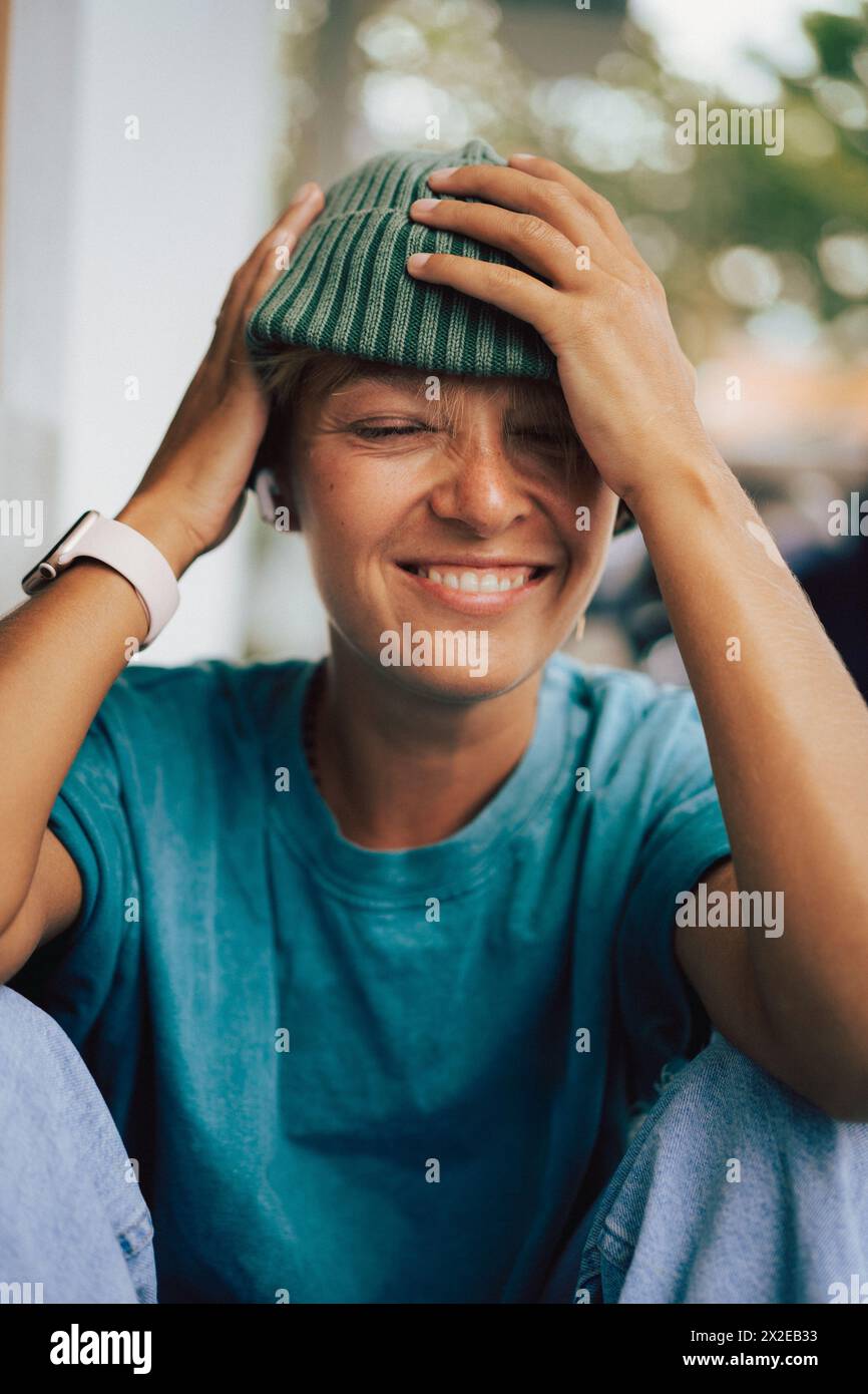 Happy laughing woman pulling her cap over her eyes. Fool Stock Photo ...