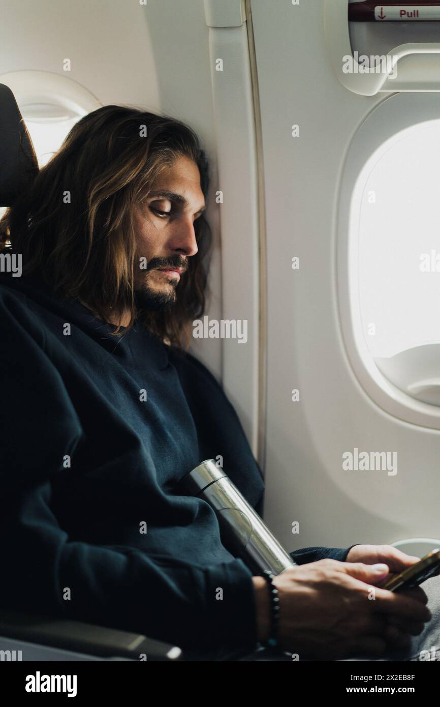 Man on a plane works from phone and is connected during the flight ...