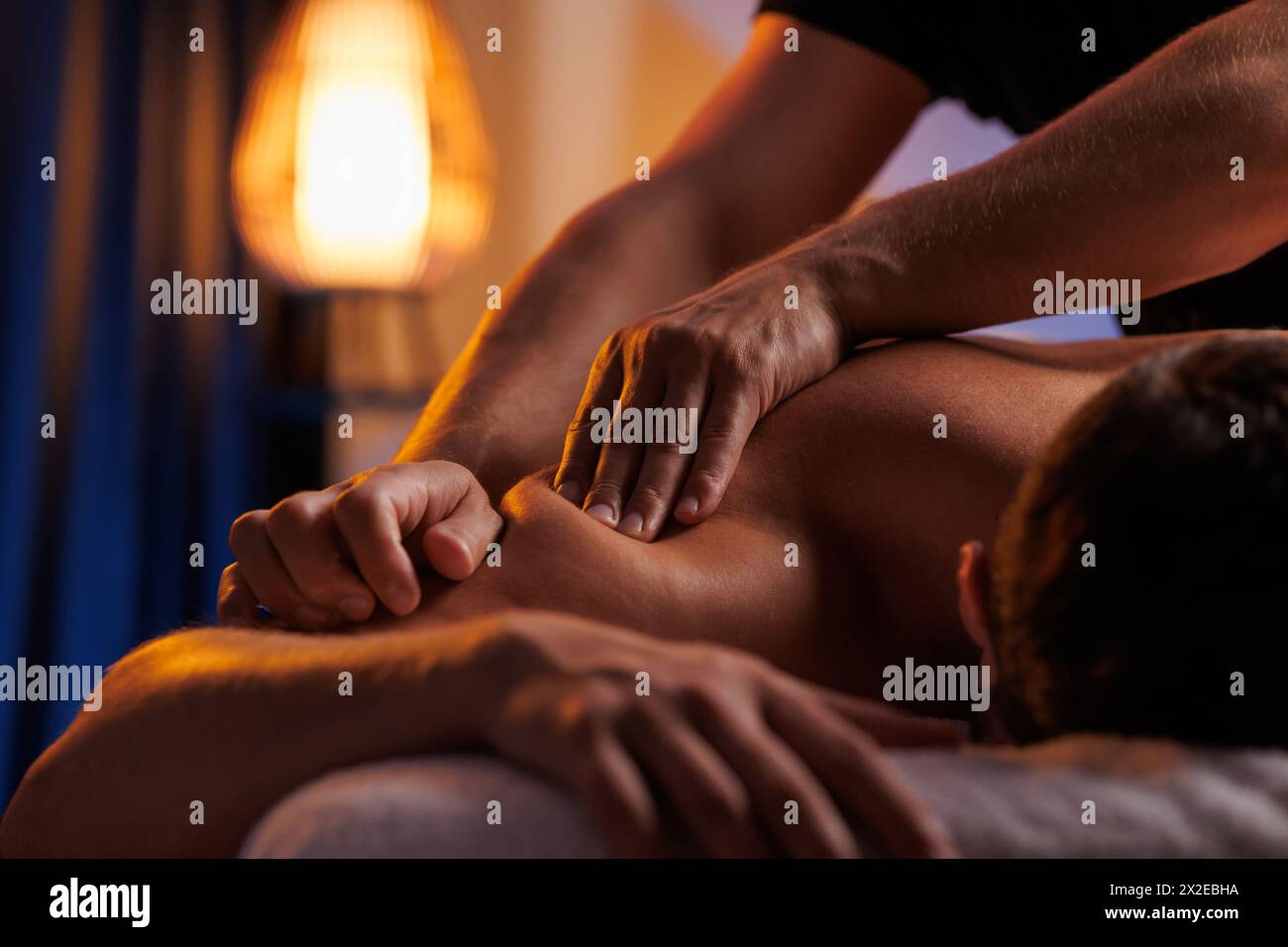 Physiotherapist massaging male patient with damaged shoulder muscle ...