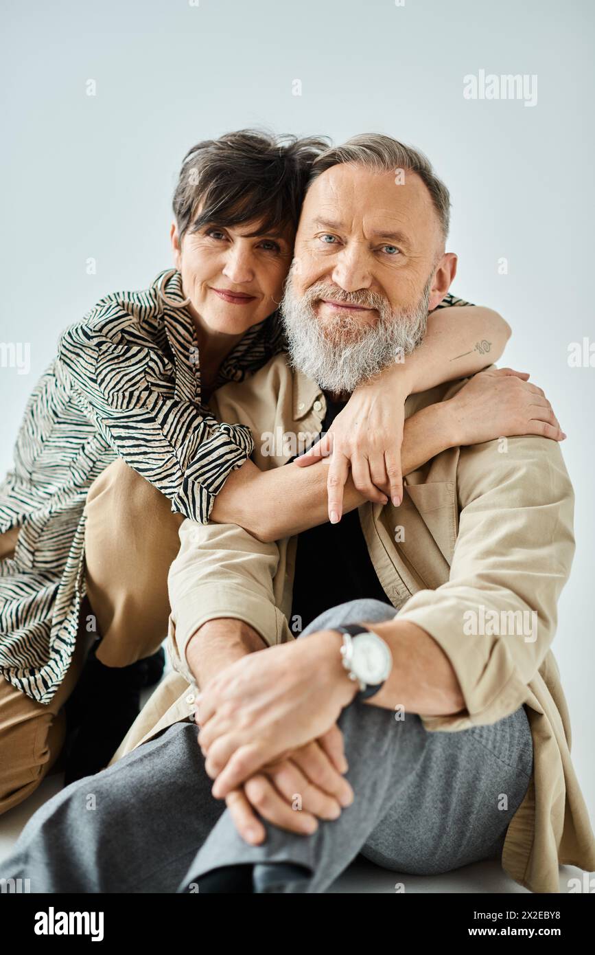 A middle-aged couple in stylish attire share a heartfelt hug ...