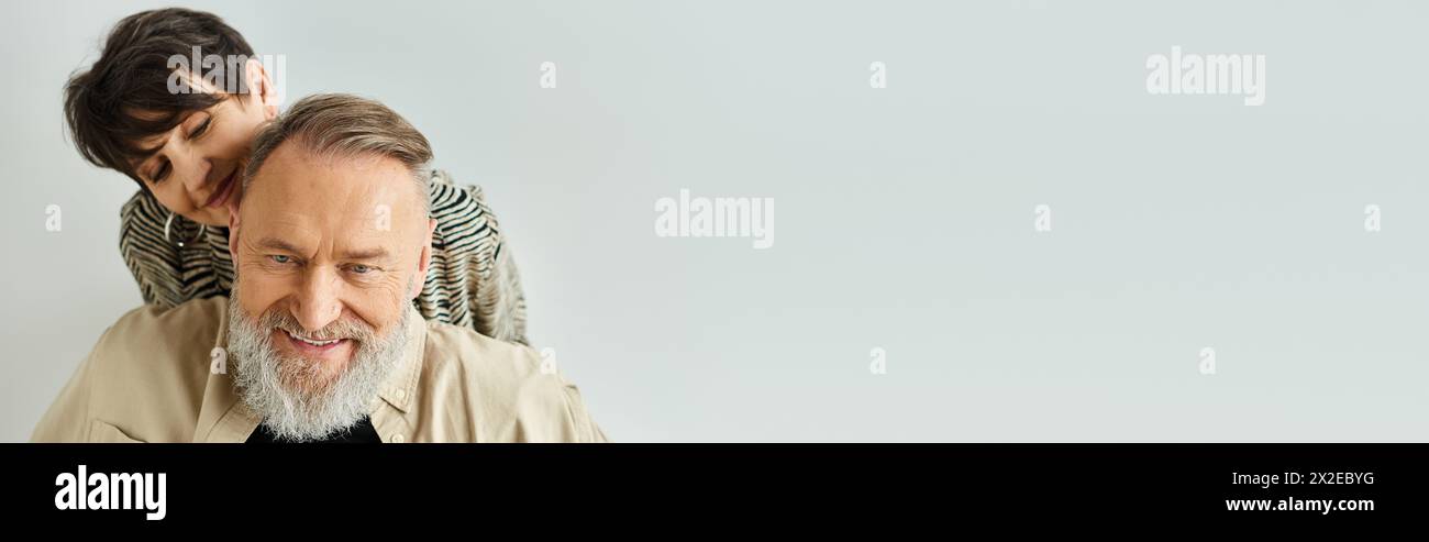 A middle-aged man lifts his partner onto his shoulders, both dressed ...