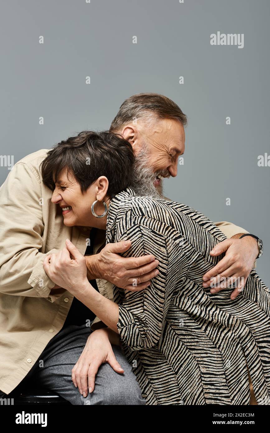 A middle-aged man lovingly hugs a woman from behind on the back of a ...