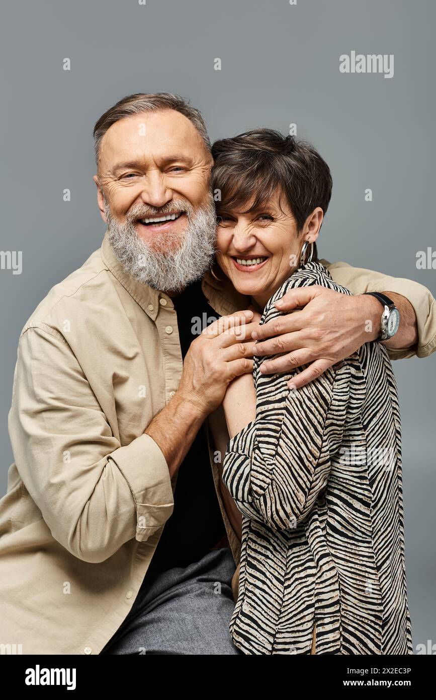A middle-aged man and woman in stylish attire share a heartfelt hug in ...