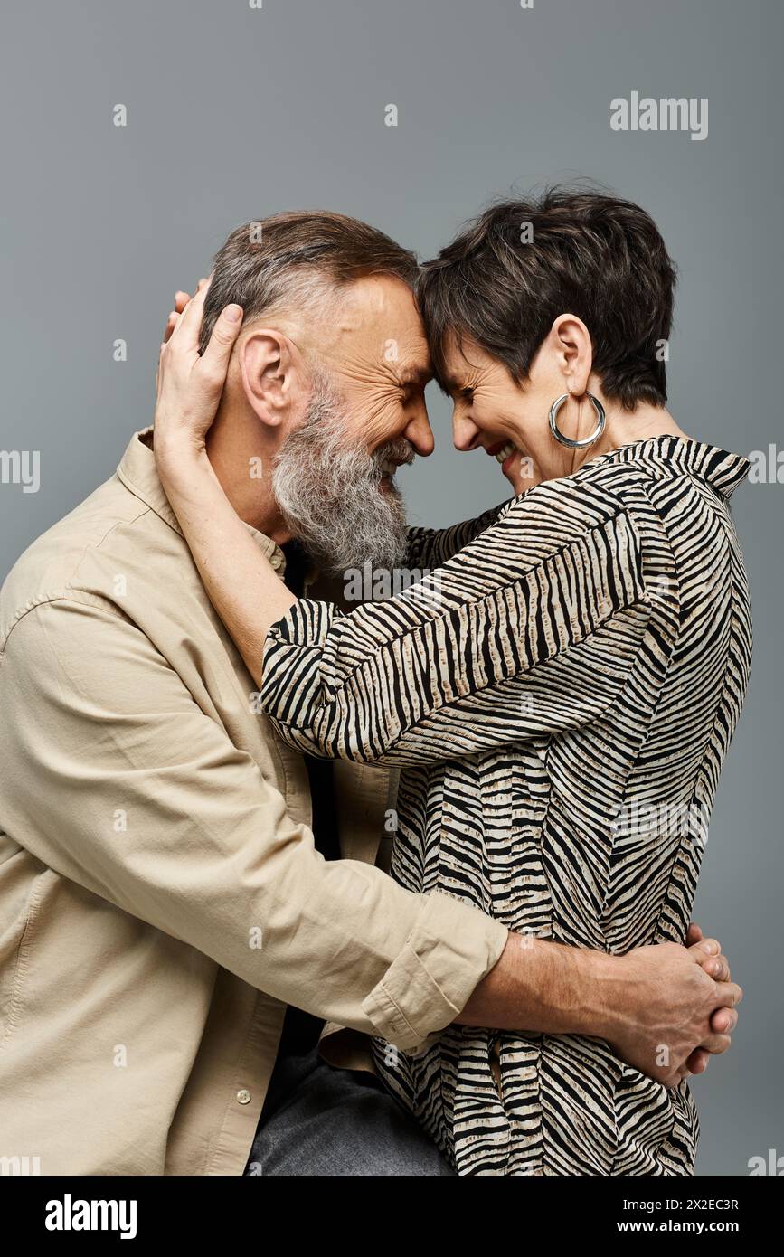 A middle-aged couple in stylish attire sharing a warm, intimate hug in ...