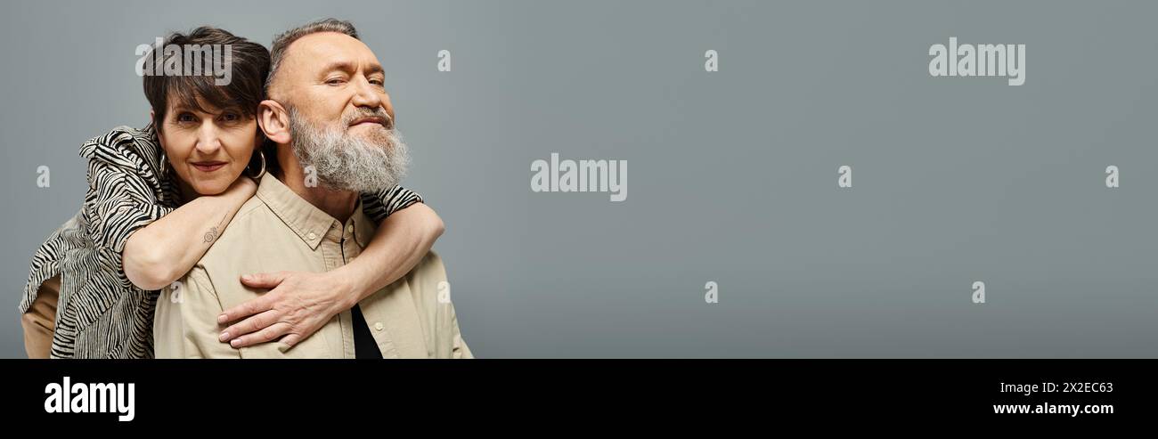 A middle-aged man and woman in stylish attire share a heartfelt embrace ...