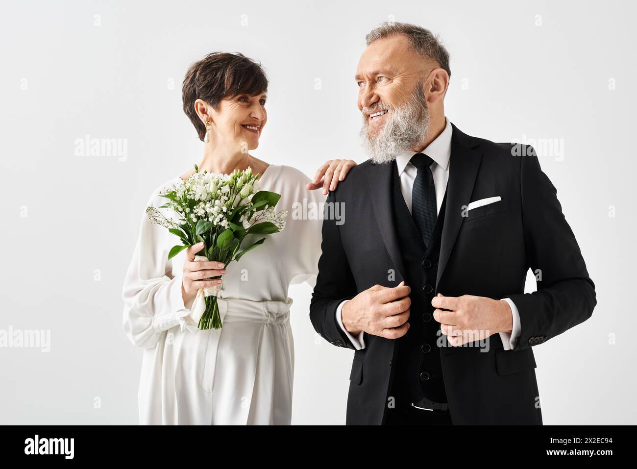 A middle-aged bride and groom celebrate their special day in a studio ...