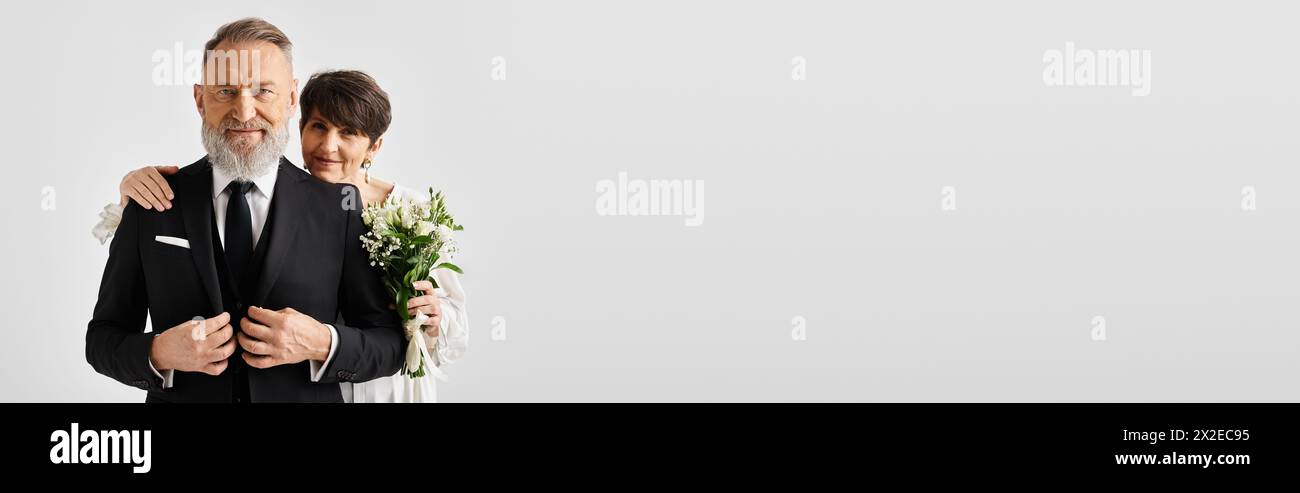 Middle-aged bride and groom in wedding gowns celebrate their special ...