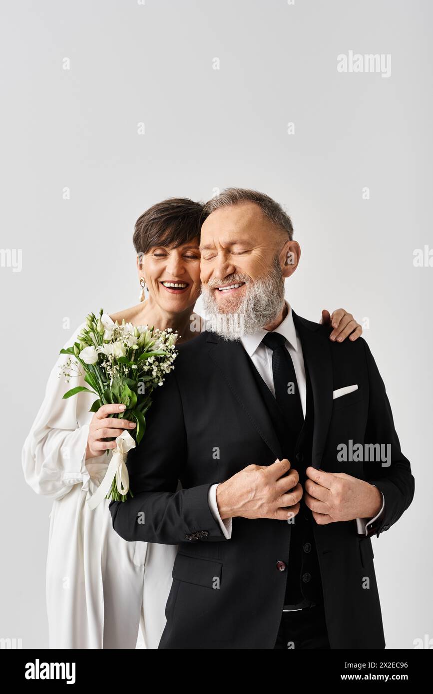 A middle-aged bride and groom in wedding gowns joyfully hugging each ...