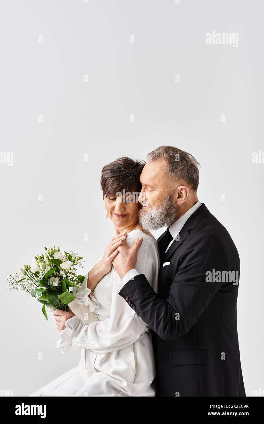A middle-aged bride and groom in wedding gowns pose elegantly in a ...