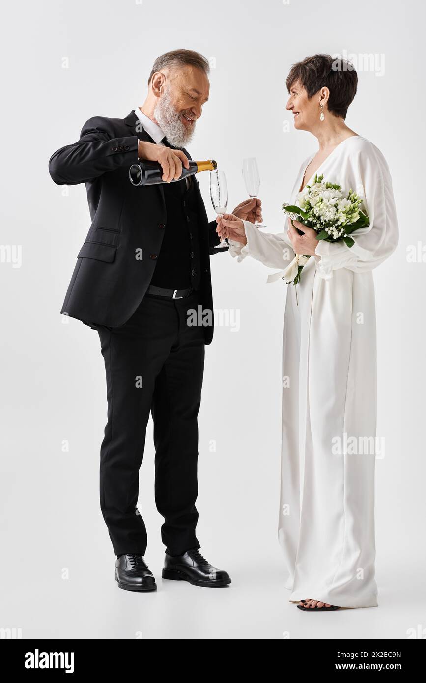 Middle-aged bride and groom in wedding gowns holding champagne glasses ...