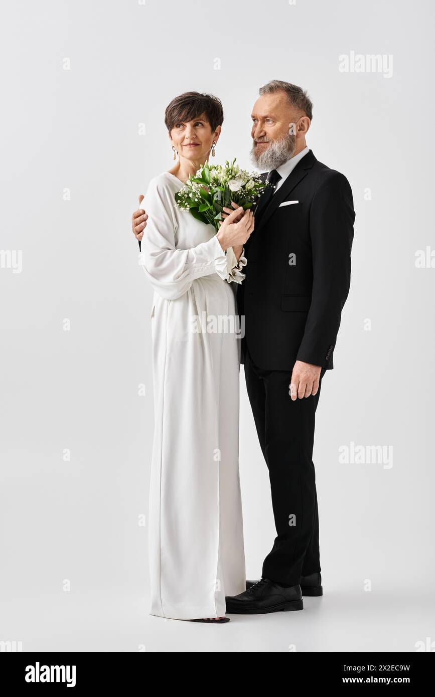 A middle aged bride and groom dressed in white wedding attire, clasping ...