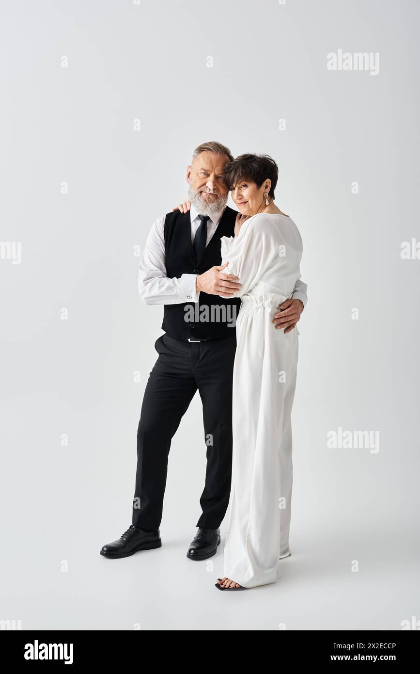 A middle-aged bride and groom in elegant formal wear pose gracefully ...