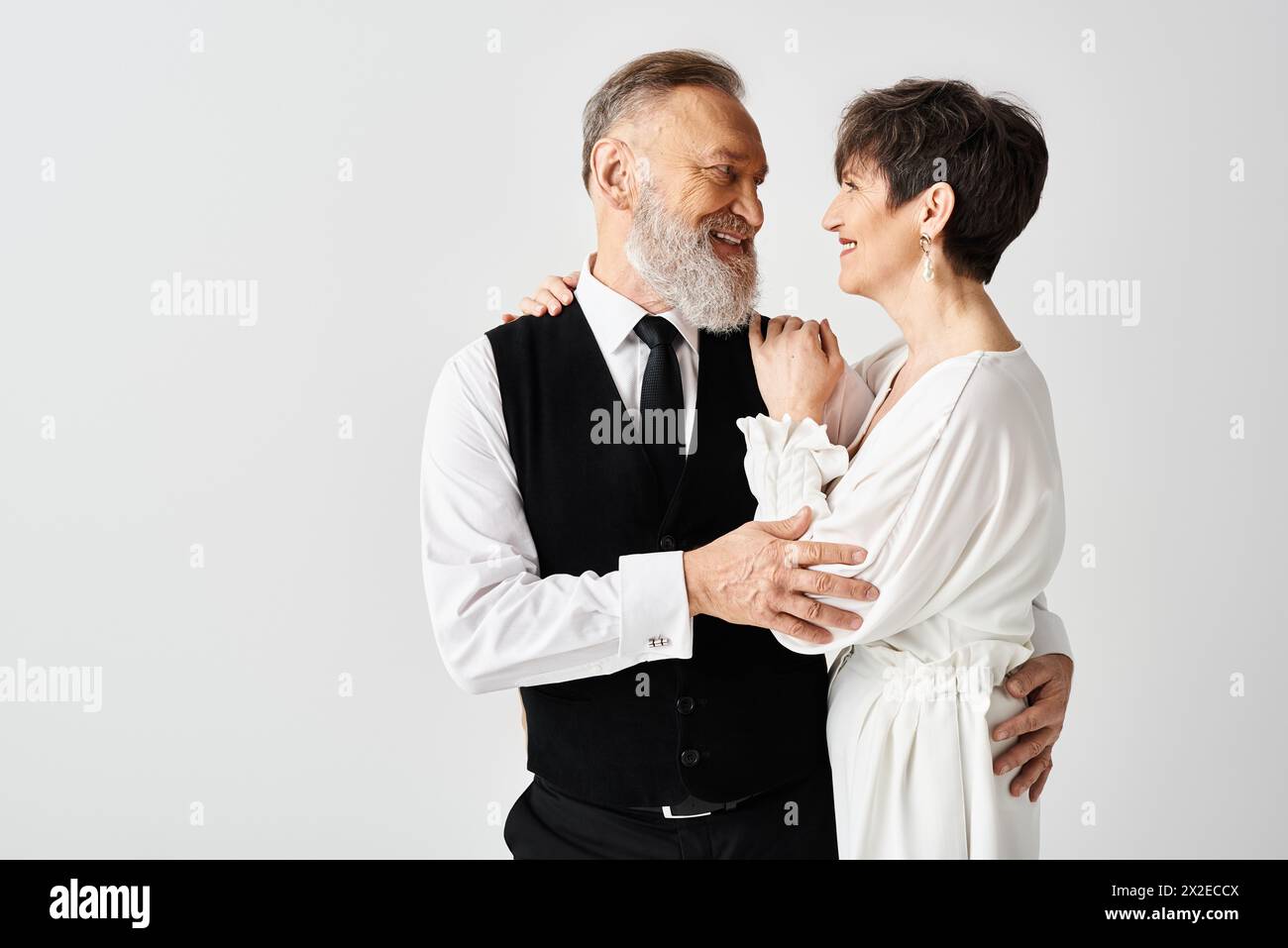 A middle aged bride and groom in wedding gowns celebrating their ...