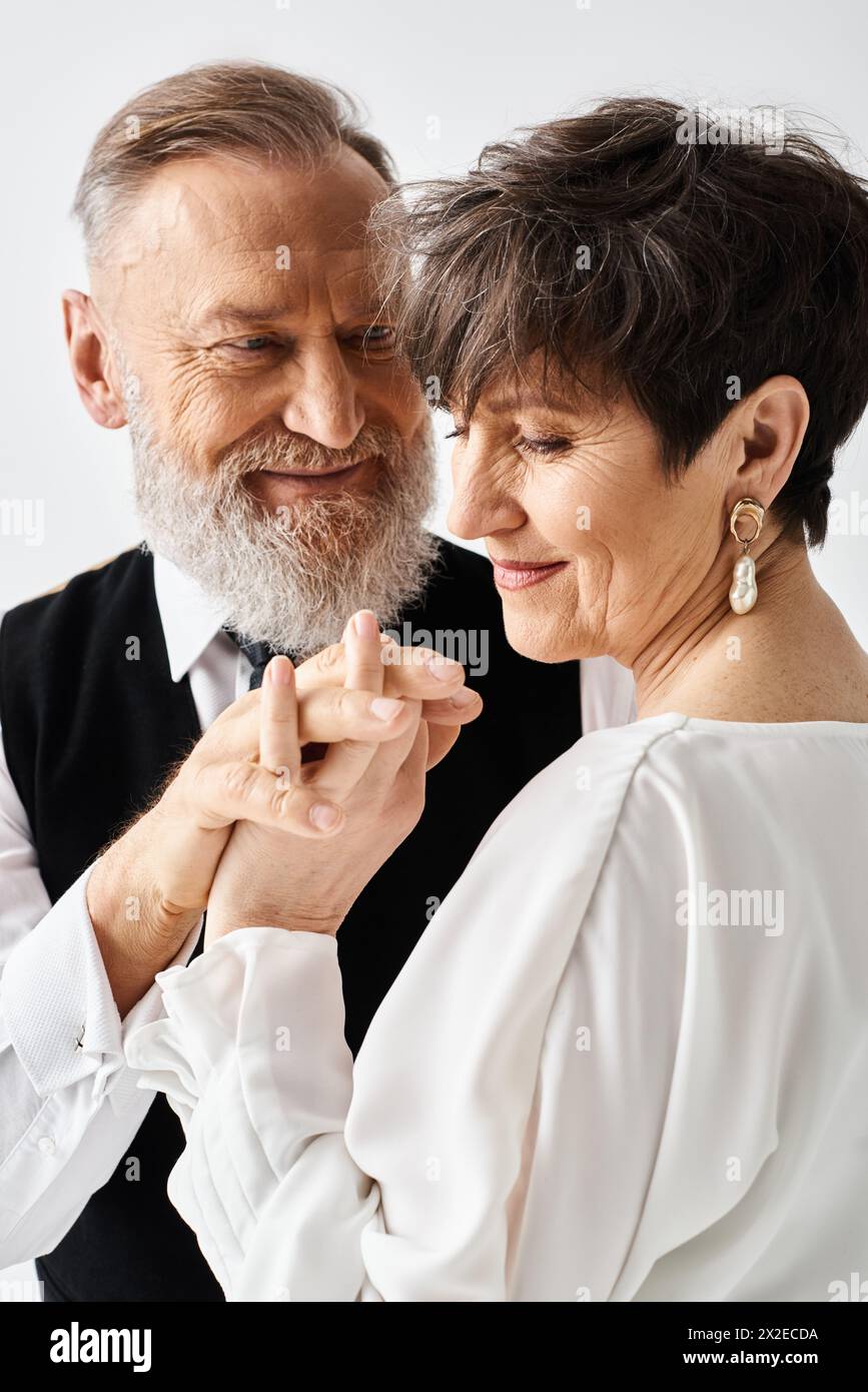 A middle-aged bride and groom in wedding attire joyfully embrace in a ...