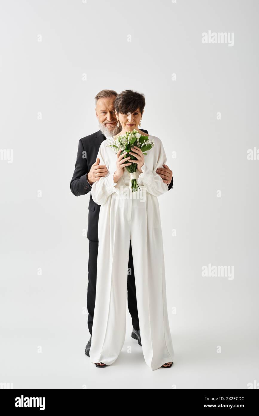 A middle aged bride and groom in wedding gowns celebrate their special ...