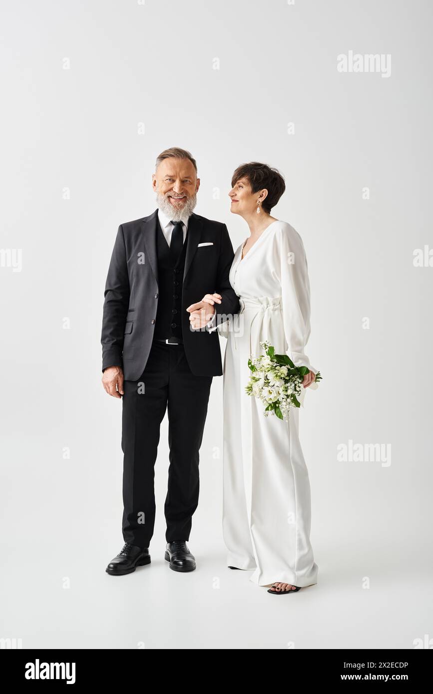 A middle aged bride and groom in wedding attire celebrating their ...