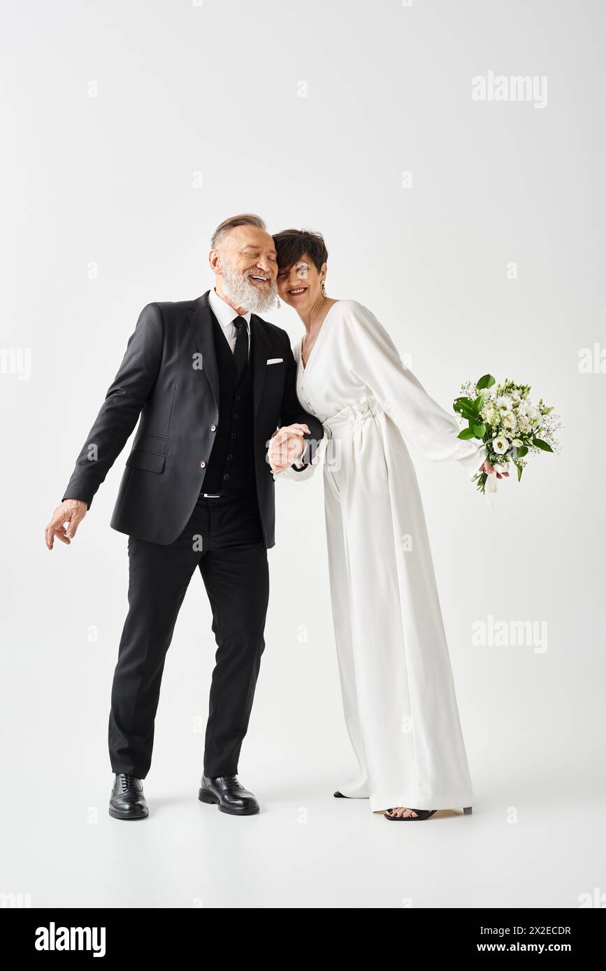 Middle-aged bride and groom, dressed in wedding gowns, strike a pose in ...